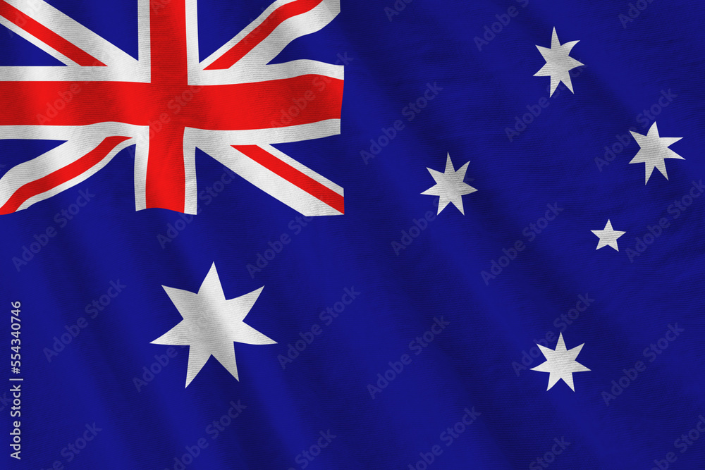 Australia flag with big folds waving close up under the studio light ...