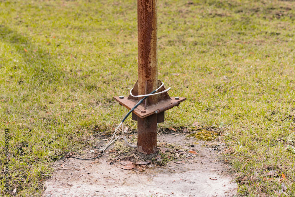 Bared wire on a rusty utility pole in the park. Dangerous. Unsafely ...