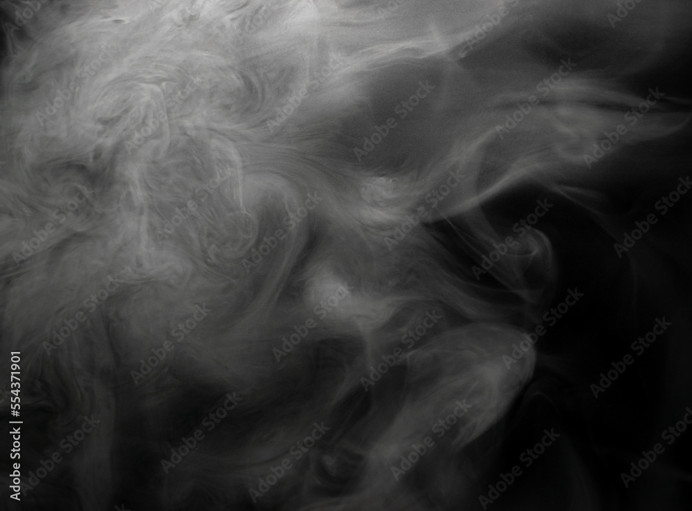 White puffs of smoke on a black background float mixing in bizarre ...