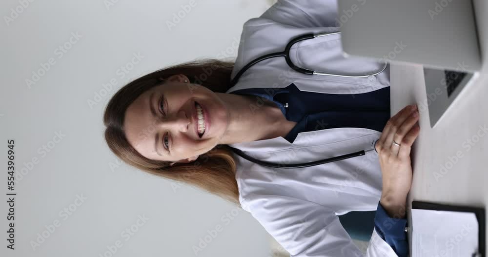 Portrait of woman healthcare worker in white uniform sit at desk in ...