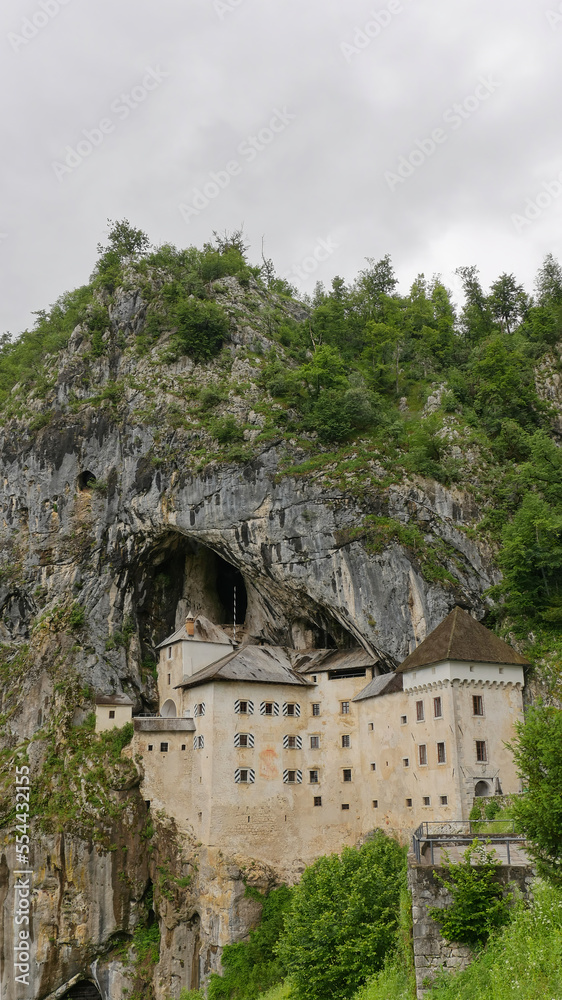 Vertical photo of Predjama Castle the largest cave castle in the world ...