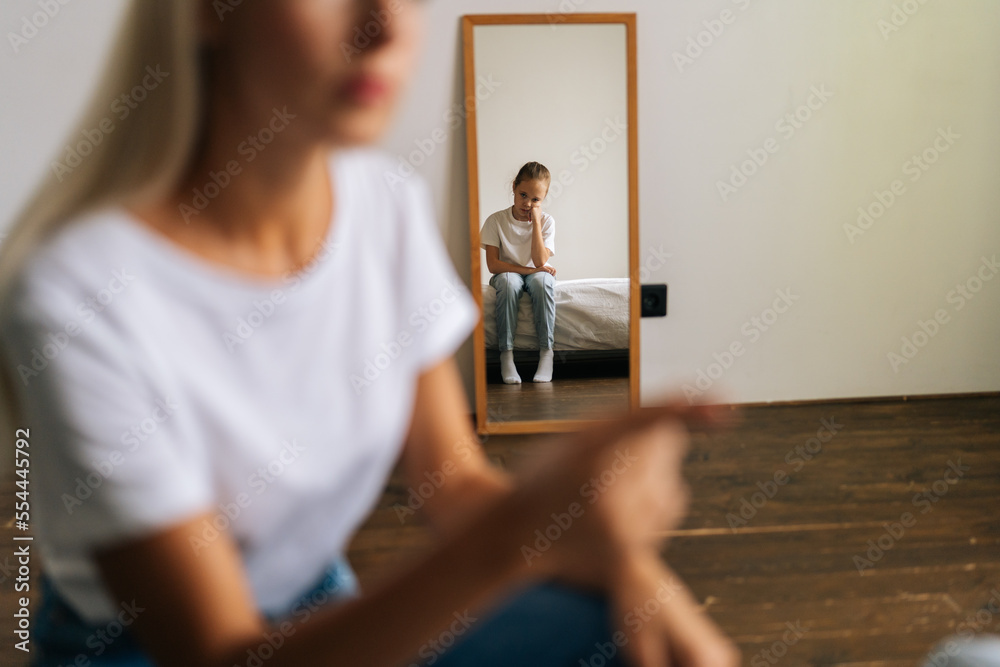 Reflection in mirror offended little girl looking at camera during ...