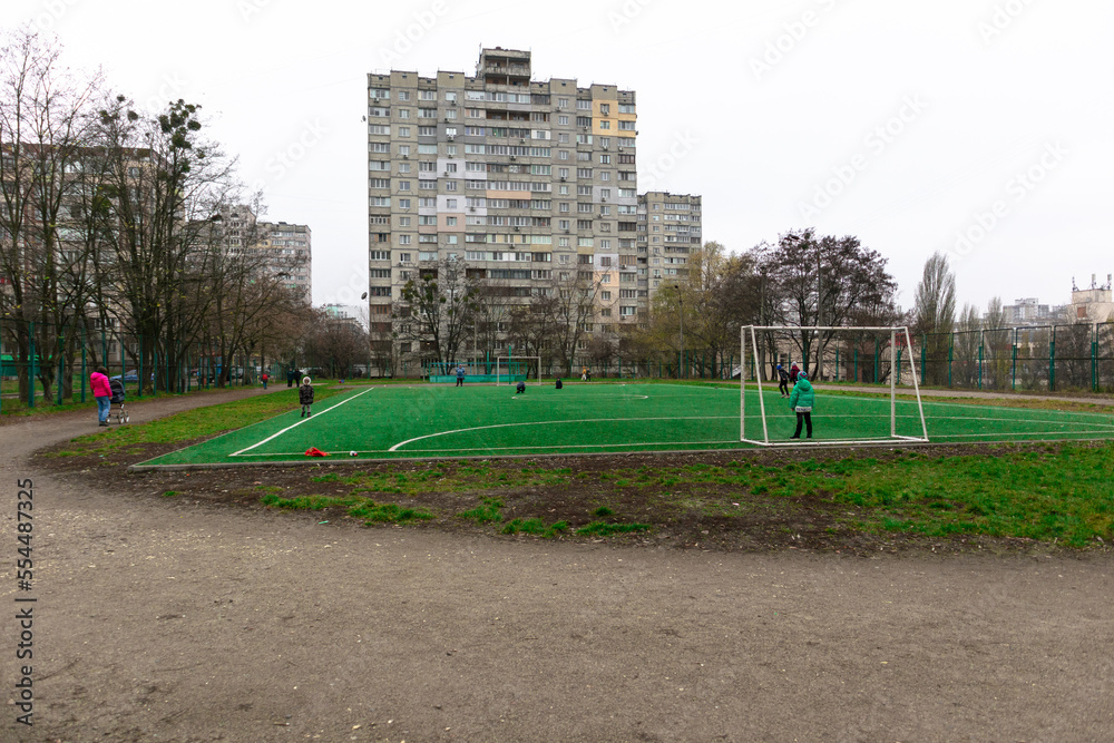Big soccer field and a few kids playing. Children play on the football ...