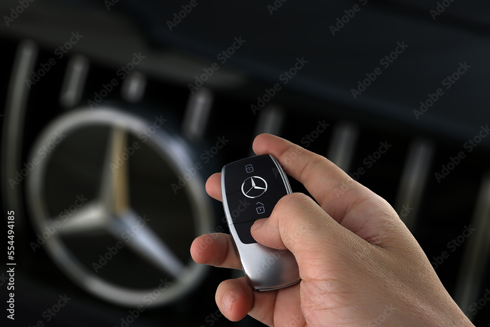 right hand holding car remote key to unlock and lock car of Benz c200 ...
