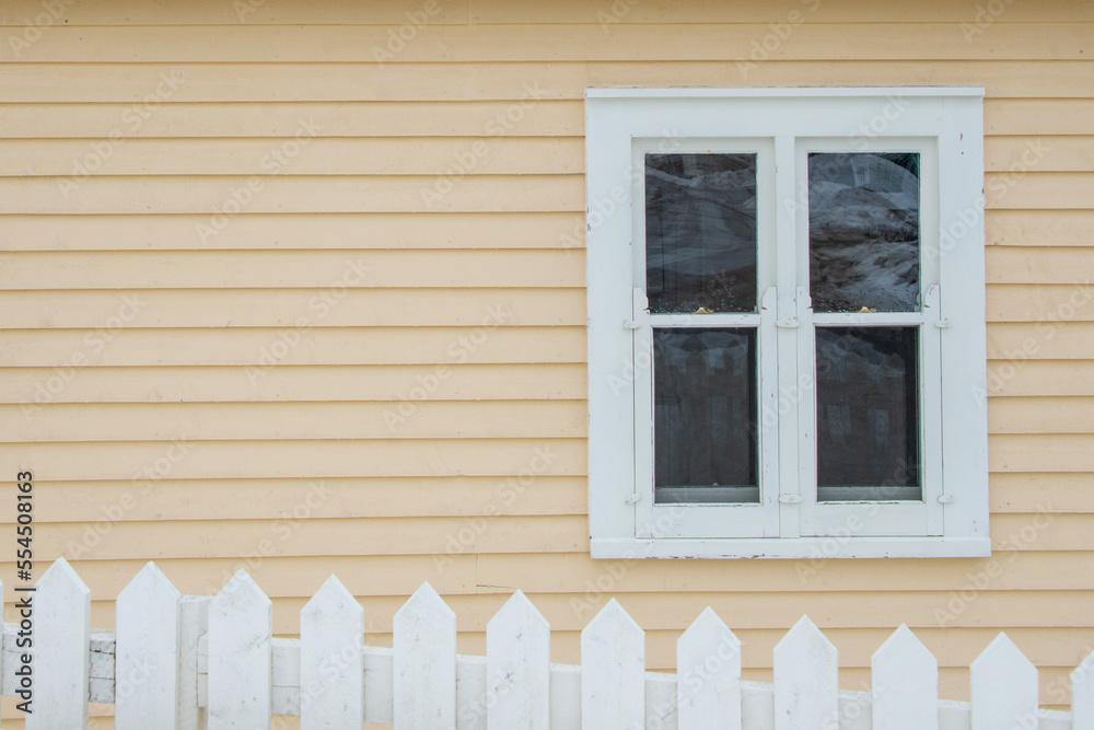 A yellow country style house with clapboard siding and a vintage double ...