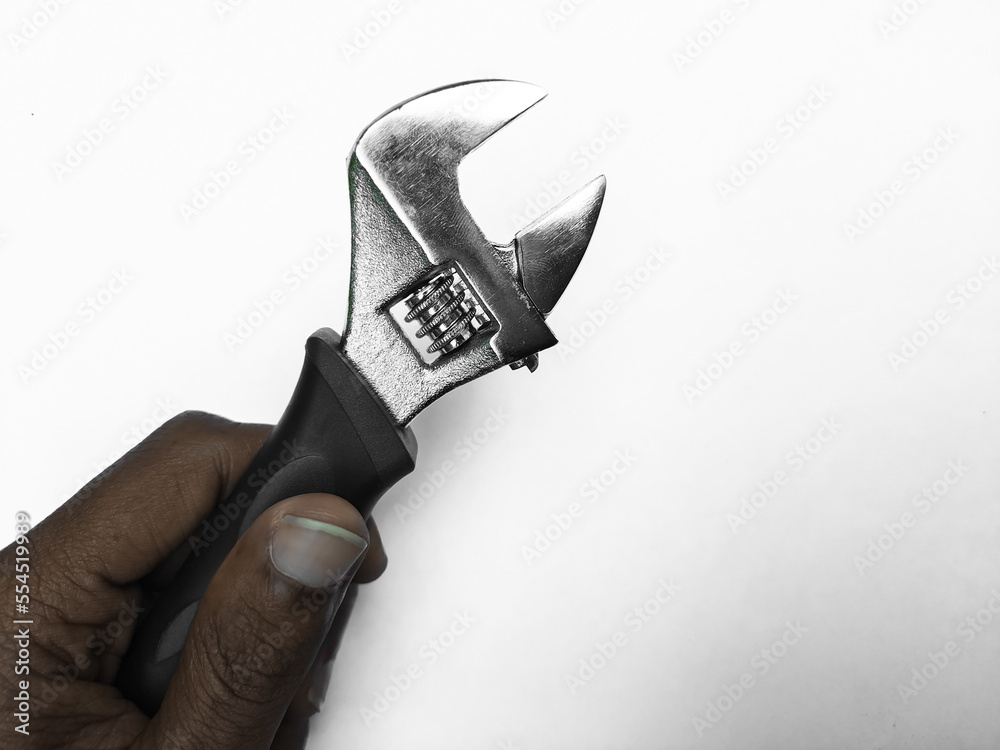 Hand holding a adjustable wrench spanner isolated on white background ...