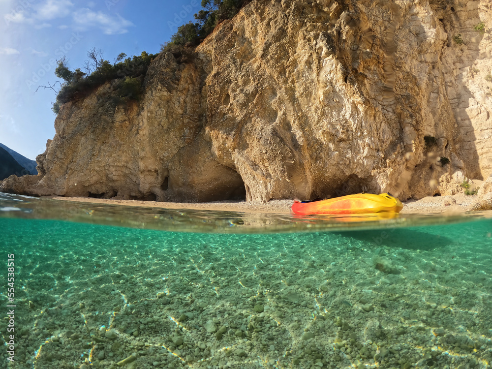Underwater split photo of sport canoe in crystal clear emerald sea and ...