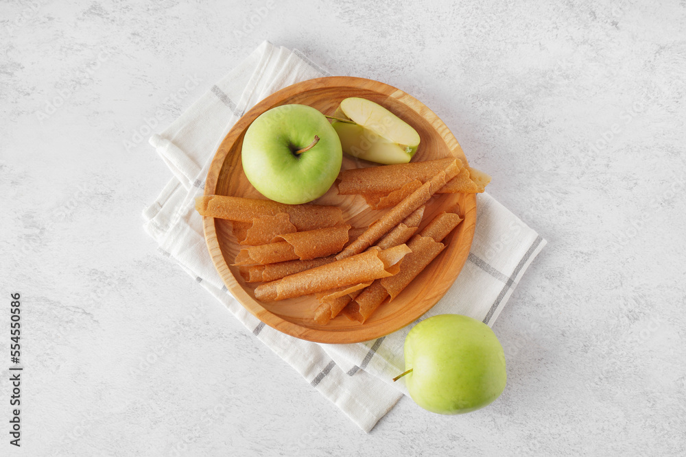 Wooden plate with tasty apple pastilles on light background Stock Photo ...