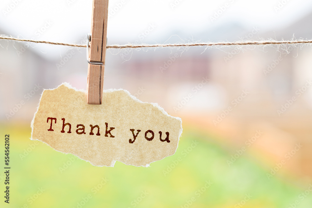 Thank you phrase printed torn paper hanging on a string with clothespin ...
