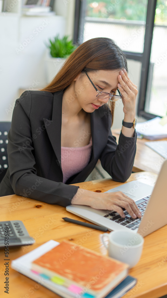 Foto de Asian women are stressed while working on laptops, Tired Asian ...