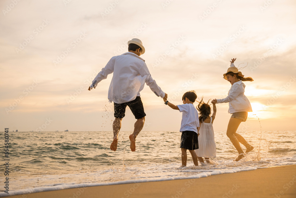 Happy Asian family have fun jumping together on beach in holiday at ...