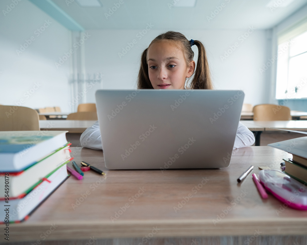Caucasian girl studying on a laptop in a classroom. Stock Photo | Adobe ...