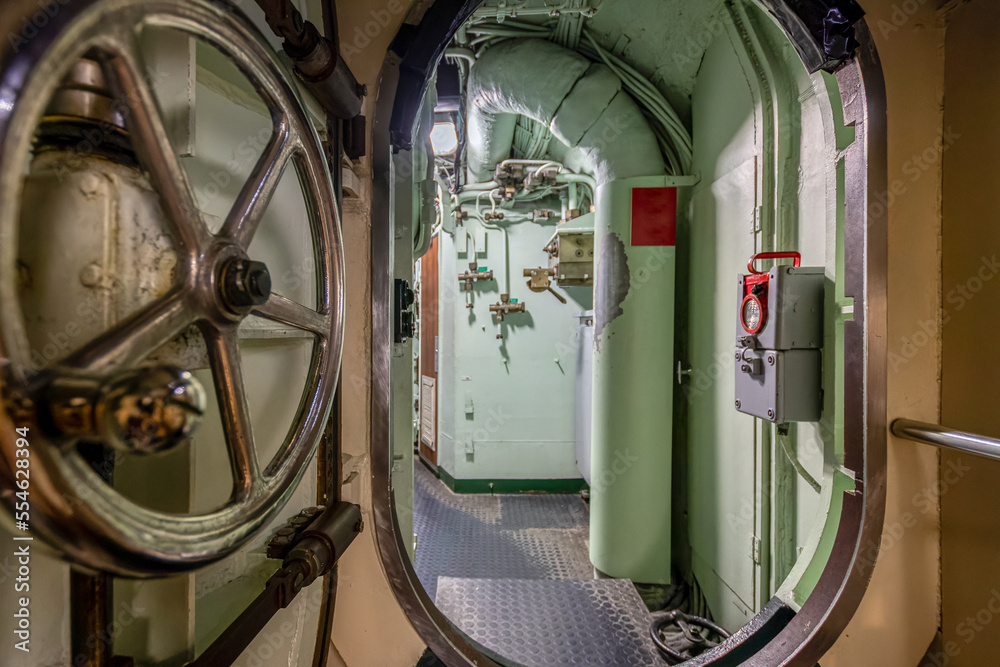 Inside a submarine with a metal door and different technical facilities ...