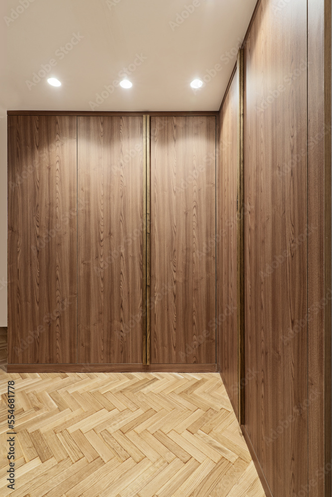 Wardrobe with root wood doors with full-length handles in the room with ...