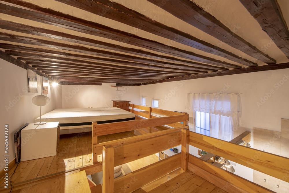 Mezzanine bedroom with wood-beamed ceilings, pinewood platform with ...