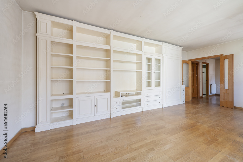 Empty living room with white lacquered wooden bookcase with glass ...