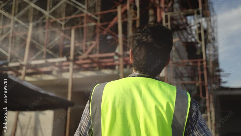 construction worker is taking off his helmet while looking at a ...