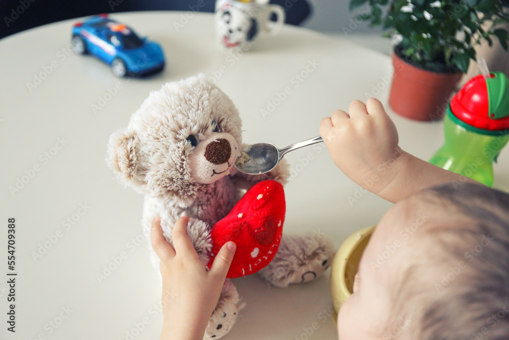 happy child eats at the table on his own. Healthy food, the child feeds ...