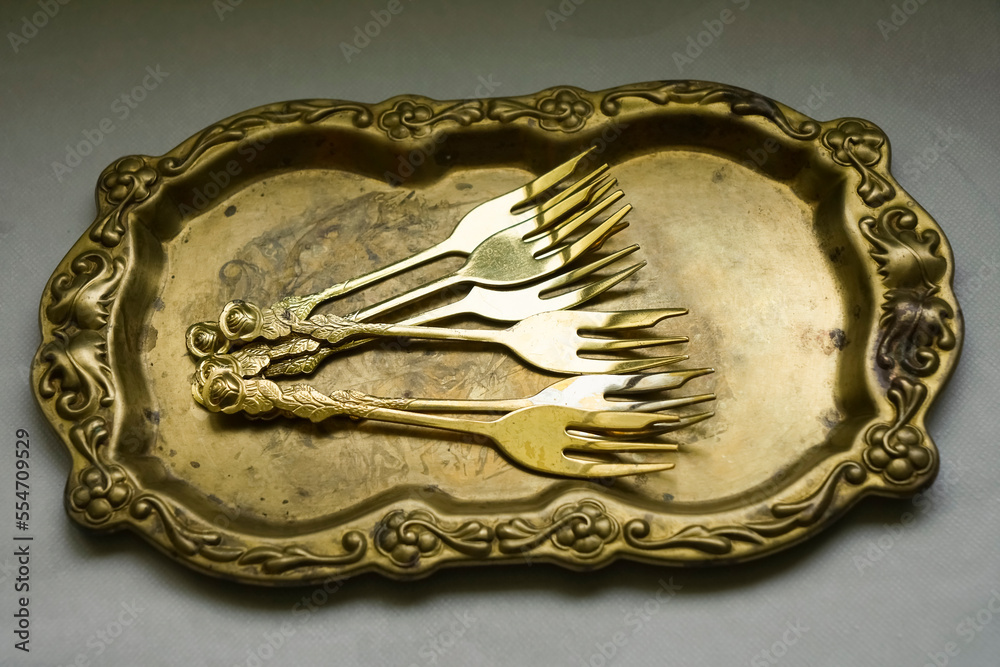 Antique golden trays with set of antique forks on a rustic table - Top ...
