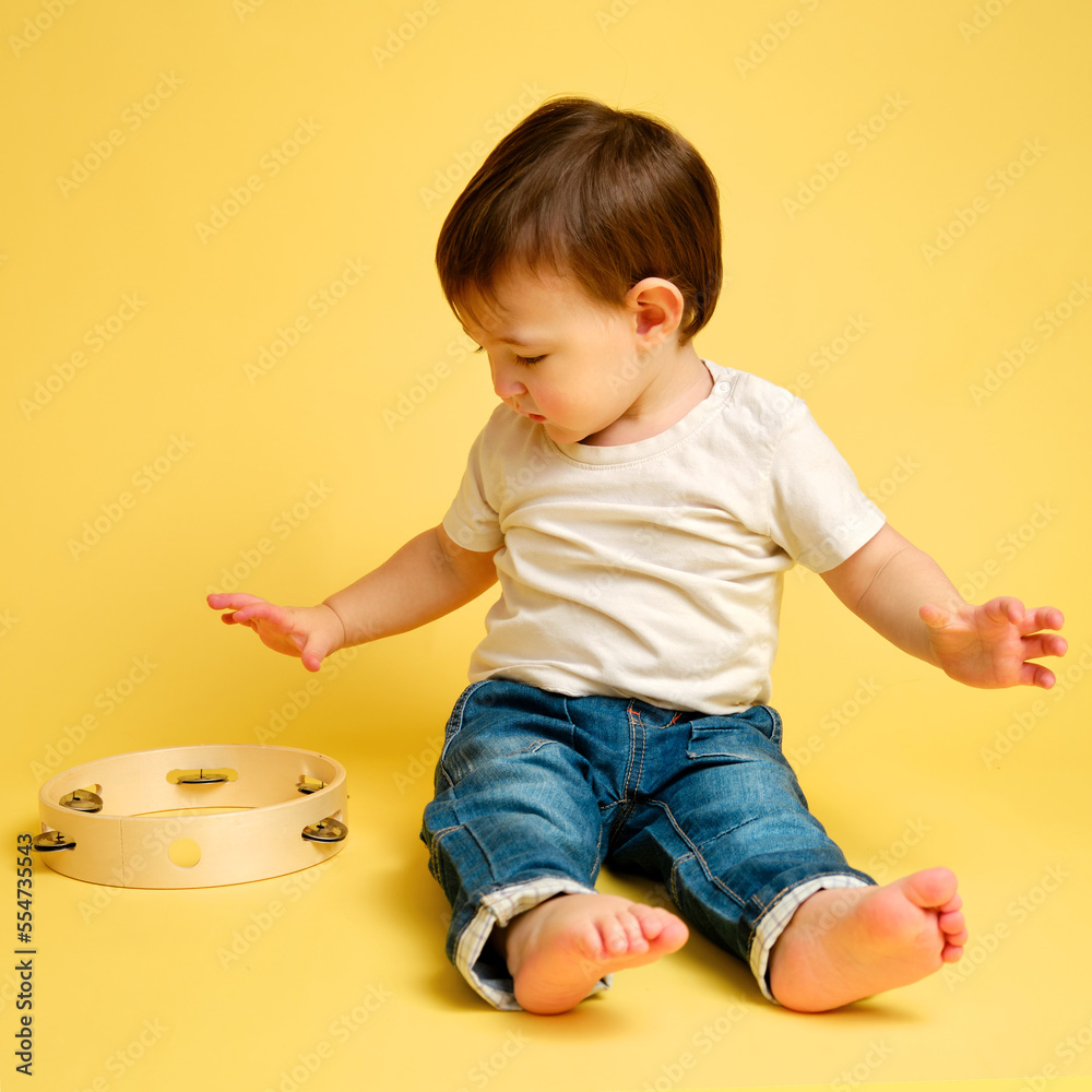 Toddler baby plays the tambourine, a child with a percussion musical ...