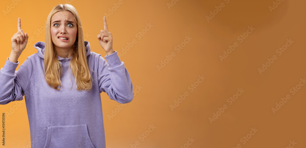 Worried perplexed unsure cute blond woman presenting project standing ...