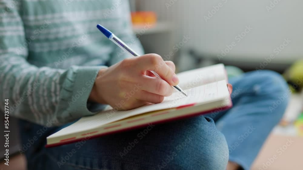 Side view blurred background girl sitting on floor and holding notebook ...