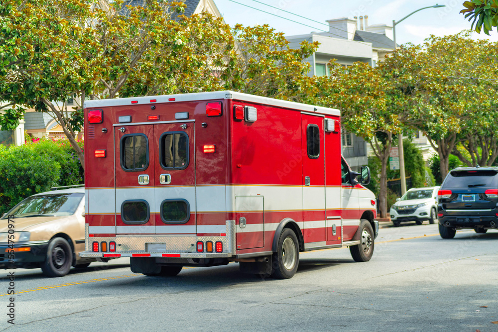 Ambulance truck as it speeds through downtown city streets in midday ...
