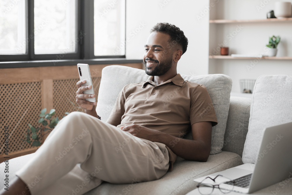 Young man using smartphone at home. Handsome man looking at mobile ...