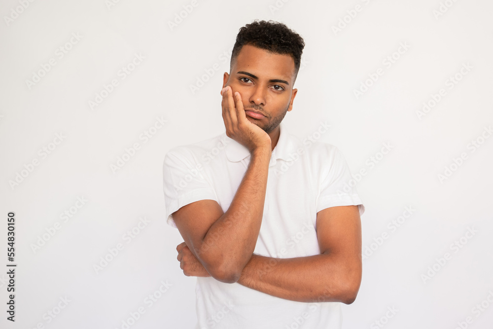Bored young man holding his face with hand. Male Indian model with ...