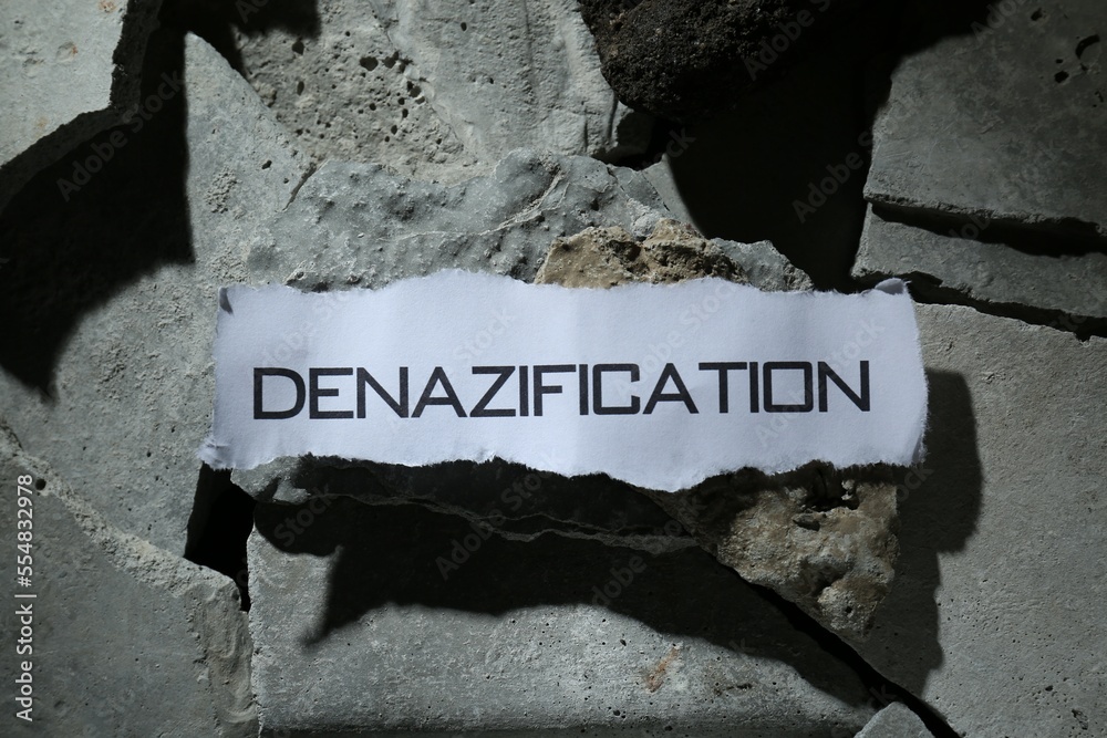 Paper with word Denazification on pieces of concrete, top view Stock ...