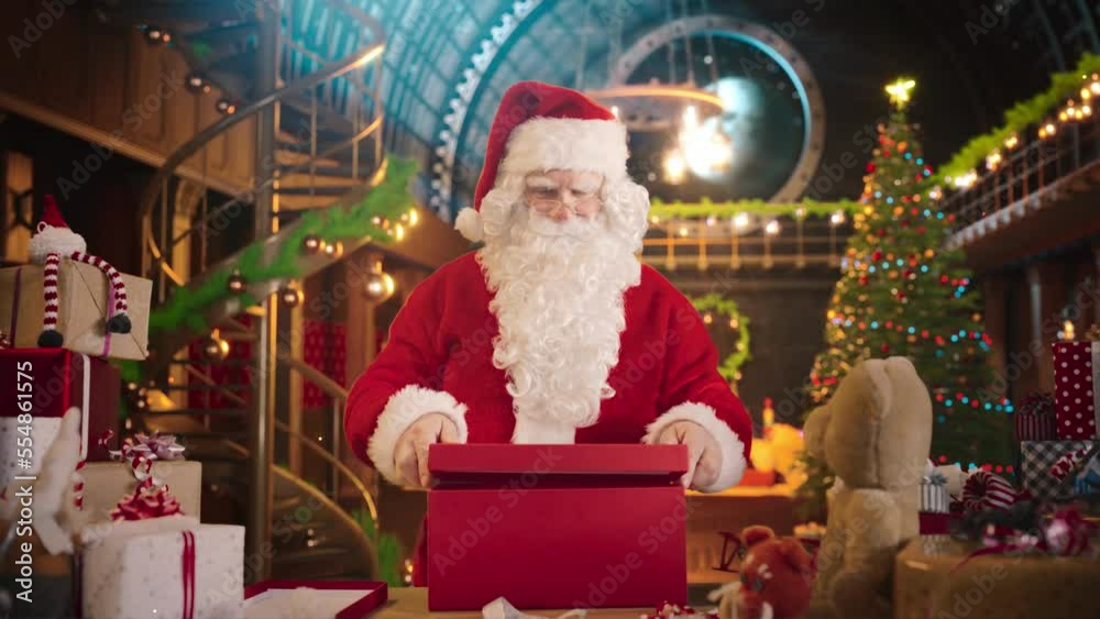 Jolly Santa Claus Works in His Studio Workshop, Wrapping and Packing ...