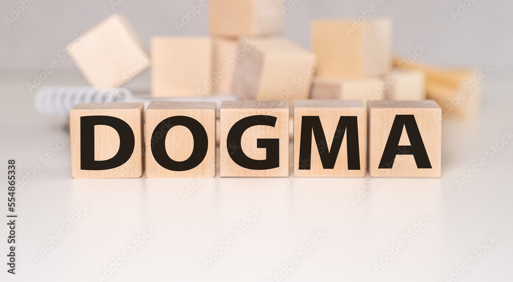 DOGMA text on the wooden block with notebooks ,keyboard with chart ...