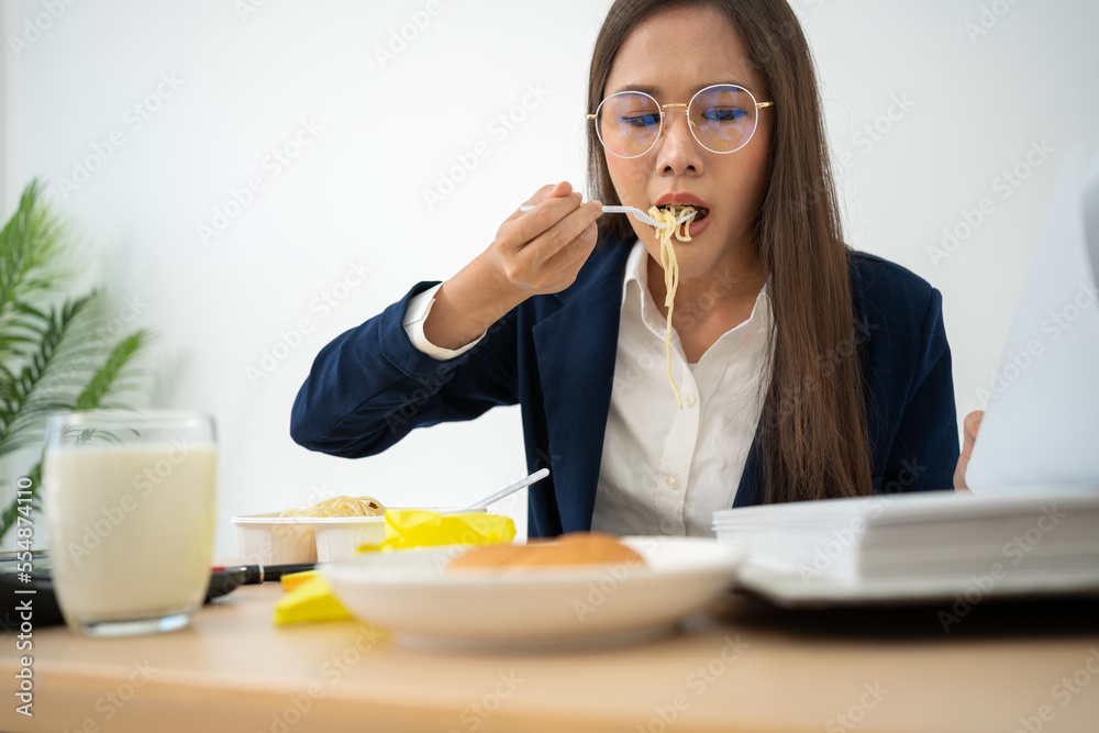Busy and tired businesswoman eating spaghetti for lunch at the Desk ...