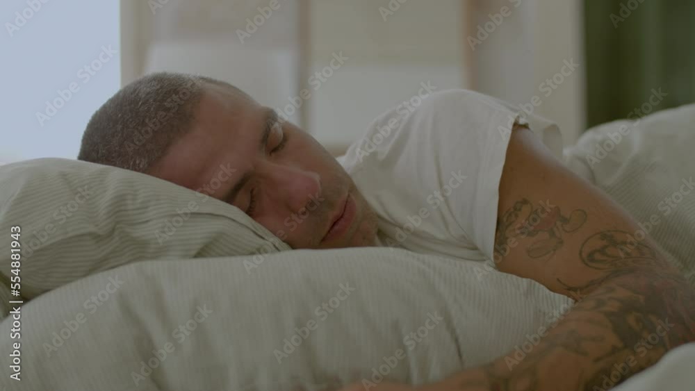 Handsome Caucasian man sleeping in bed at home. Medium shot of man ...