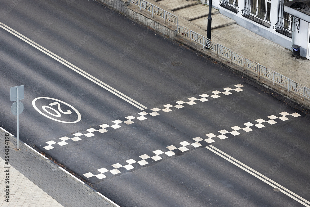 Safety speed bump on an asphalt road at city. New road markings on the ...