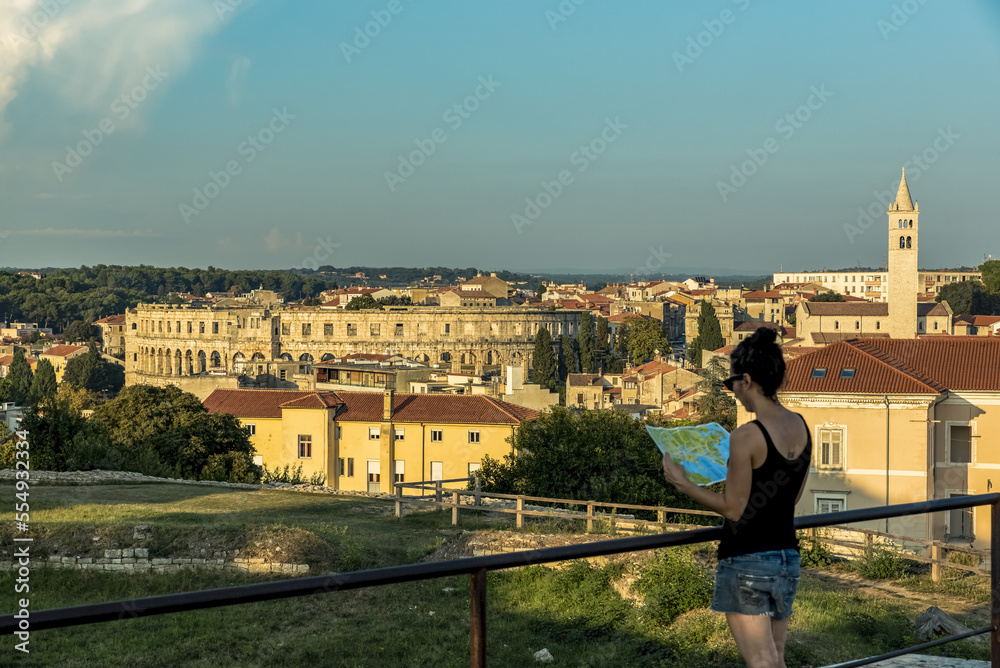 Female tourist with map at ancient Roman Amphitheatre known as Pula ...