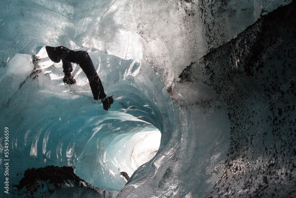 A climber descends by rope into a moulin on Skaftafell Glacier ...