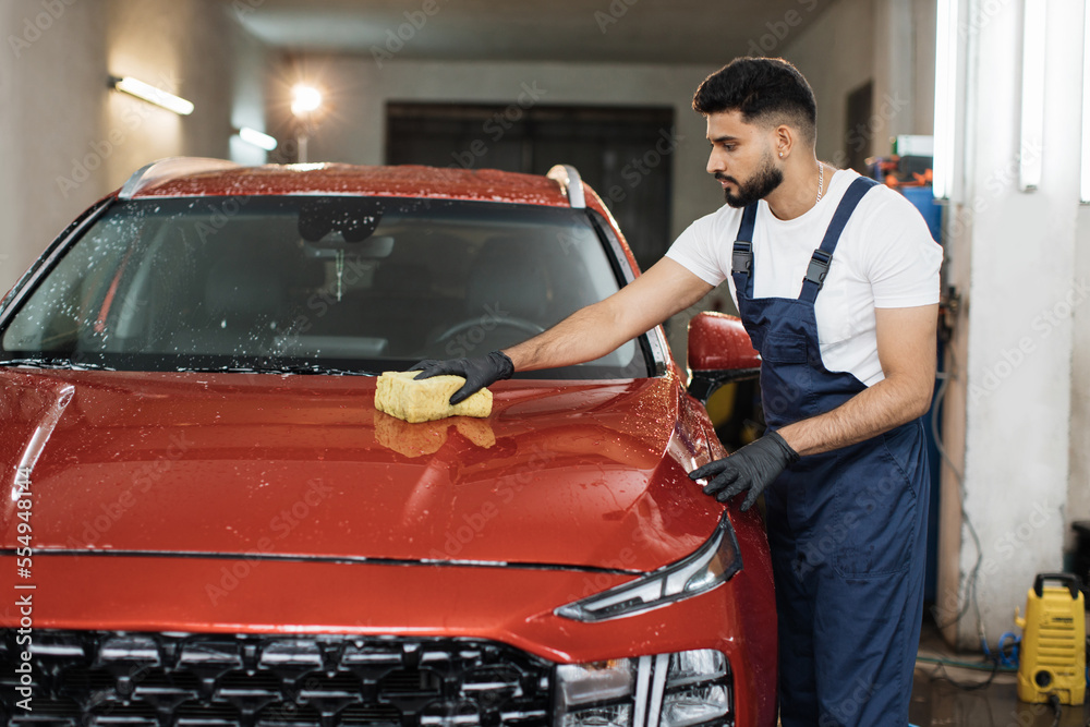 Car washing and detailing concept. Young concentrated bearded male ...