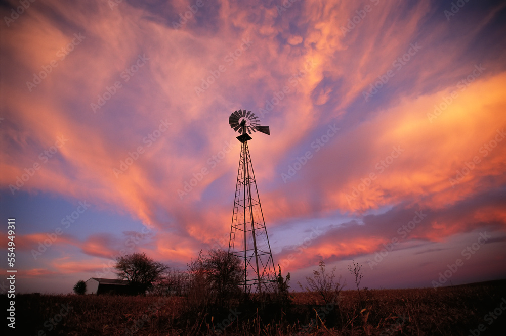 Silhouette of a tall wind vane in a glowing sunset sky; Dunbar ...