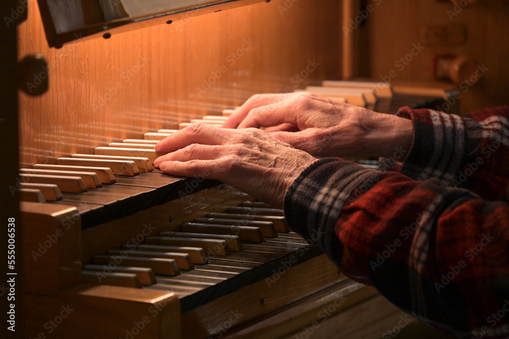 Old Hands of an organist playing on the organ keyboard also called ...