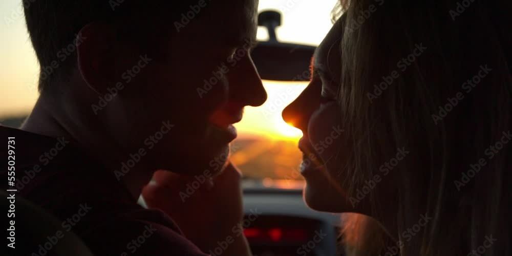 romantic young couple tenderly kiss each other and caresses in the car ...