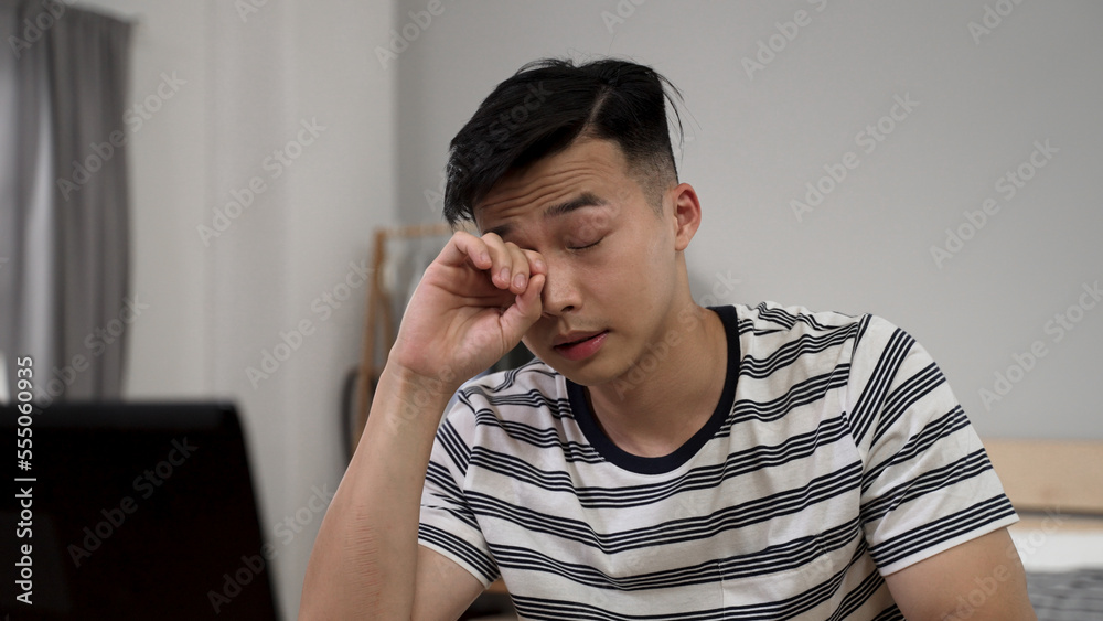 overworked asian college boy learning from home on the computer and ...