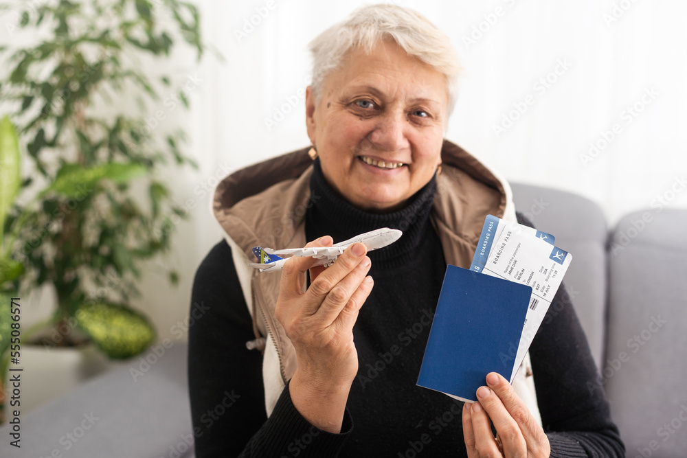 old woman holding Passport, boarding pass and toy airplane Stock Photo ...