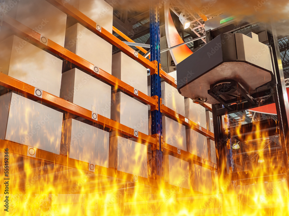 Burning warehouse. Metal shelves with boxes are destroyed by fire ...