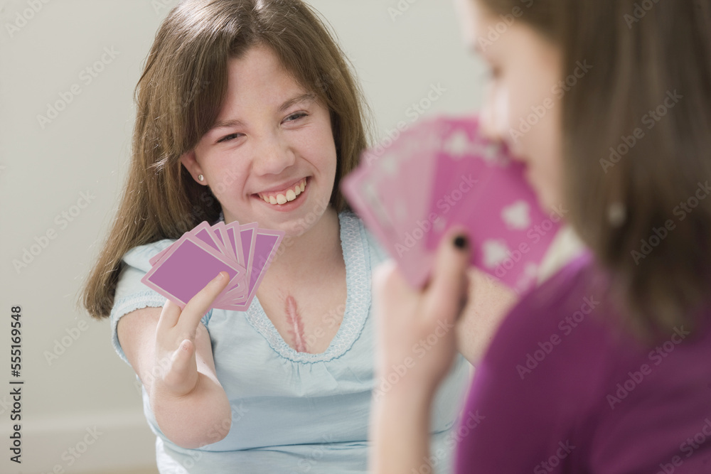 Two teenage girls playing cards, Teenage girl with birth defect talking ...