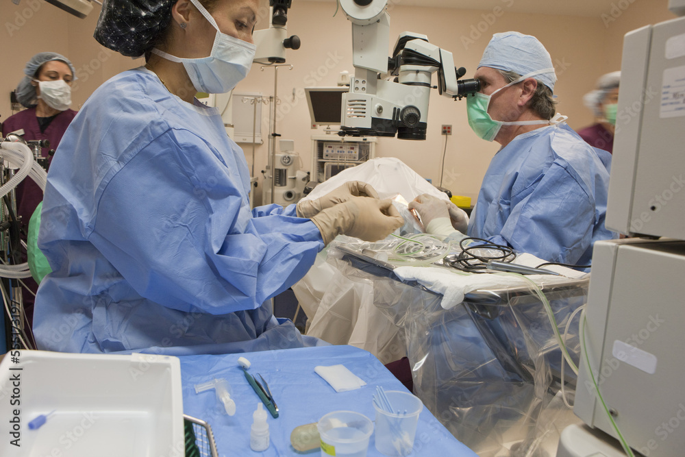 Surgical technologist putting line on the irrigation aspiration and ...