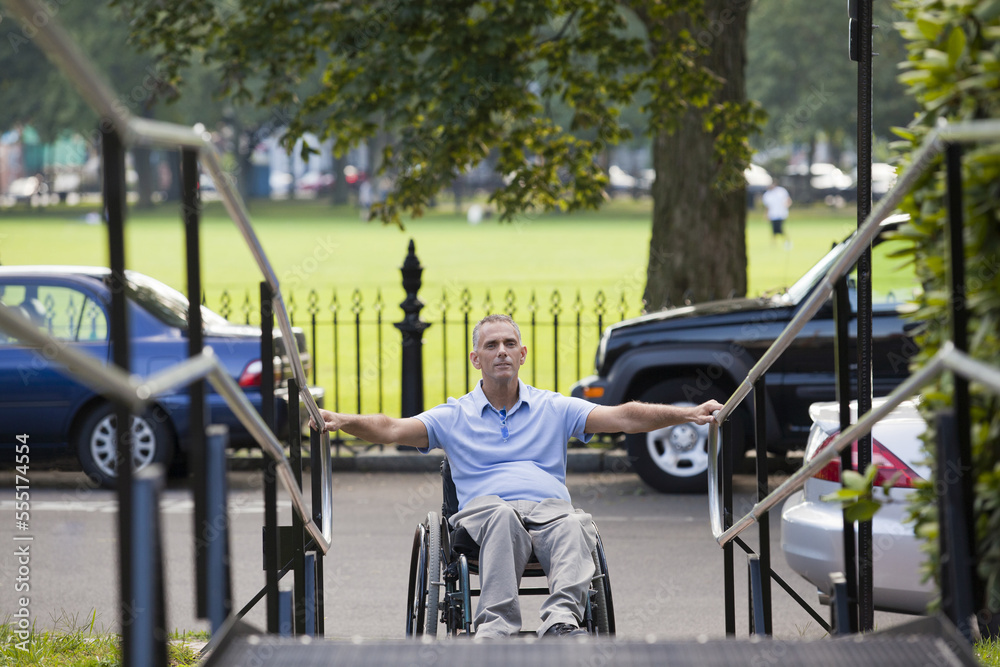 Man with spinal cord injury in wheelchair approaching outdoor ...
