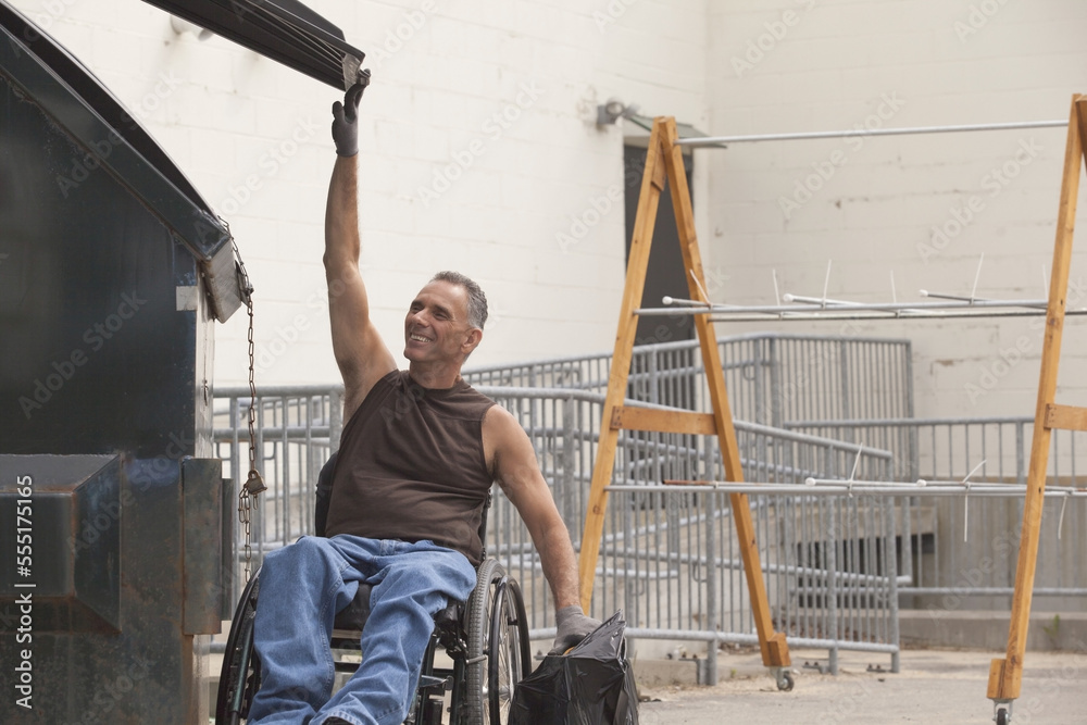 Loading dock worker with spinal cord injury in a wheelchair putting a ...