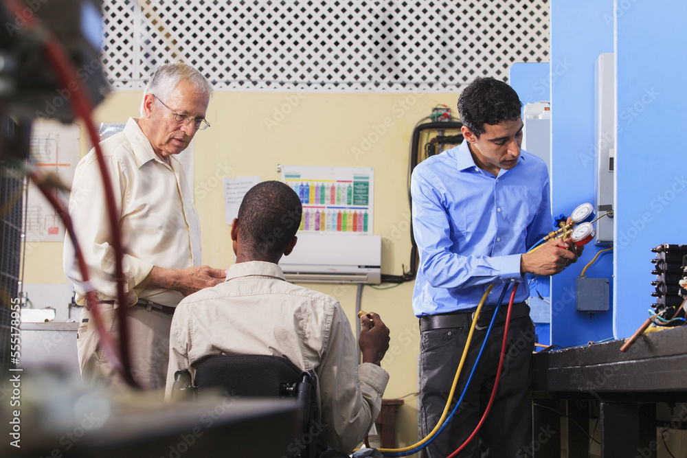 Student demonstrating air conditioner recharging manifold with gauges ...