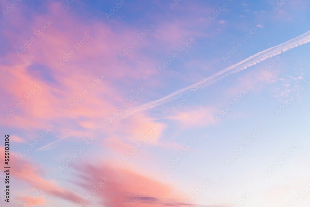 beautiful unusual pink clouds with an airplane trail at sunset, sunrise ...